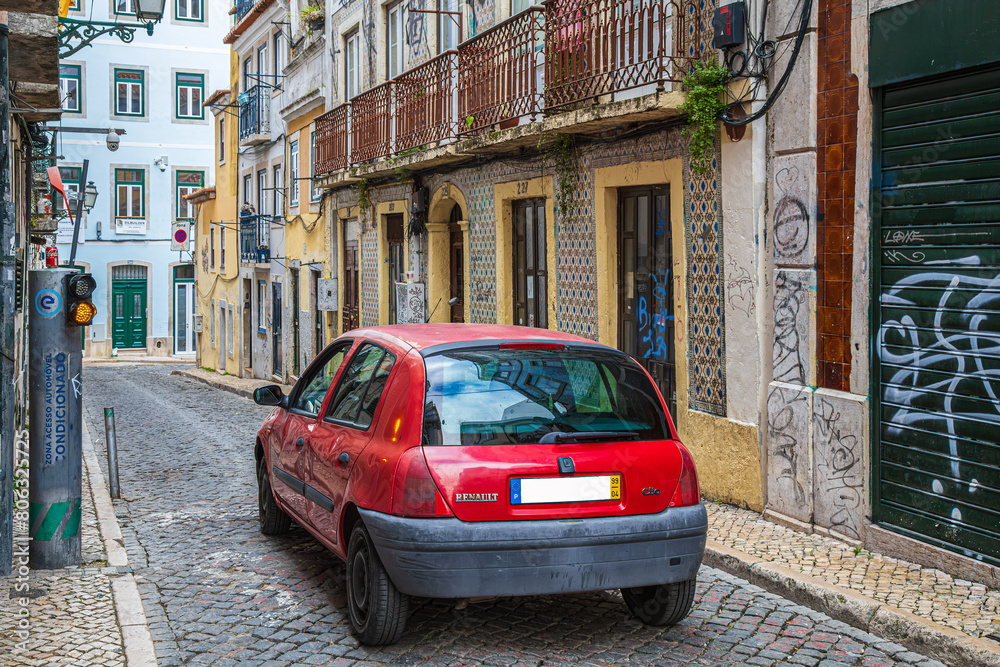 Small car stops at a small traffic light on a small street, Lisbon ...