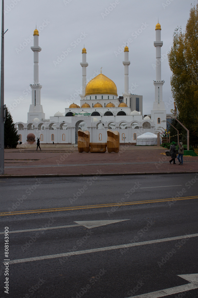 Vertical street photo. The Nur-Astana Mosque with golden dome, four ...