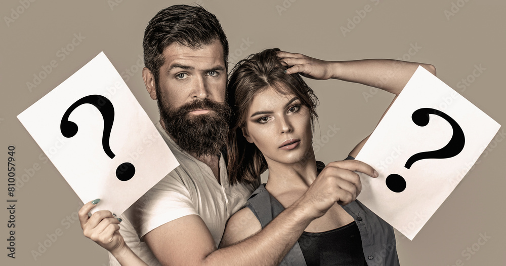 Confused couples with question marks. Portrait of couple holding paper ...