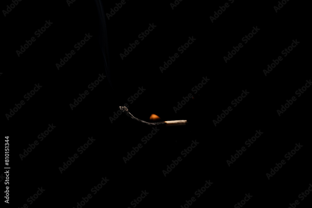 Lit falling match on a black background. Stock Photo | Adobe Stock