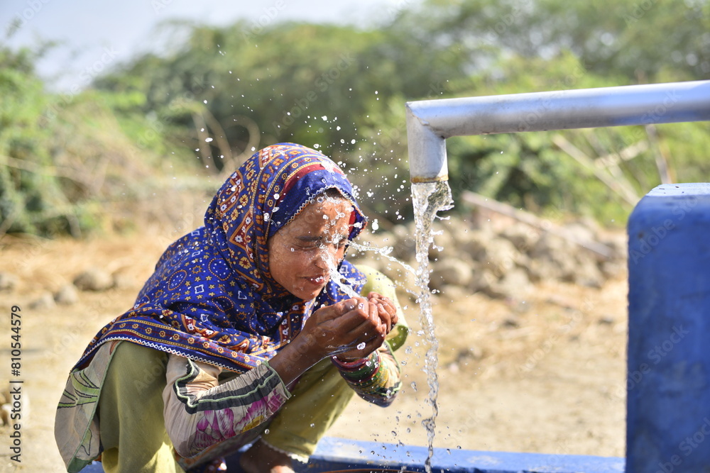 Child Drinking from a Hand Pump. Young Pakistani girl drinking clean ...
