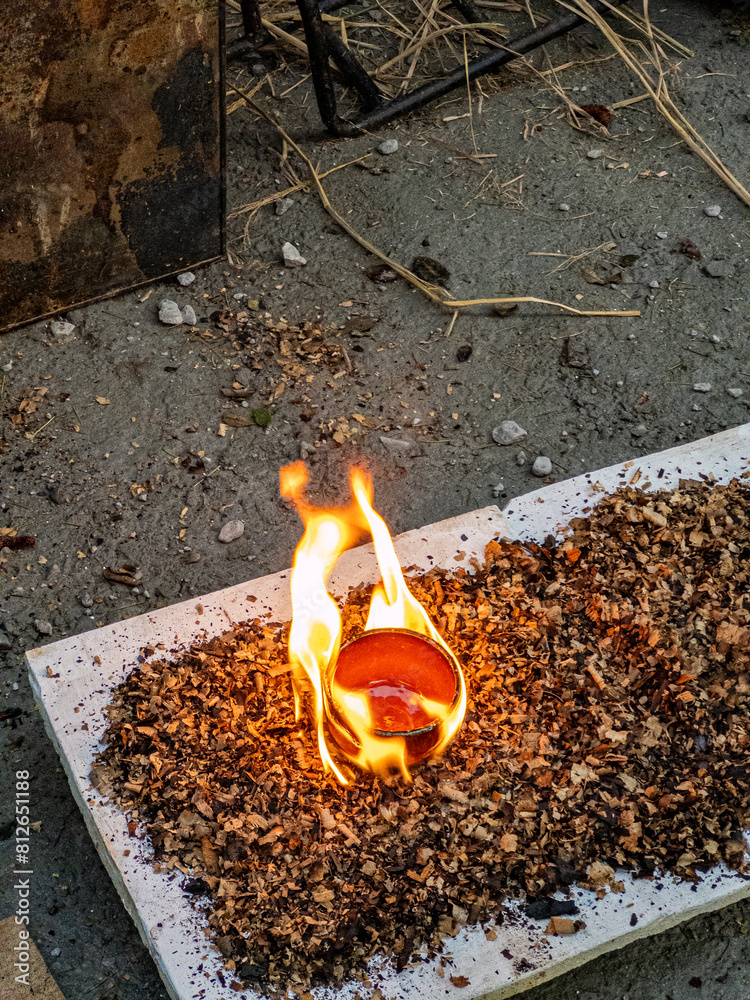 The process of Raku firing when glazed ceramics are taken from the kiln ...