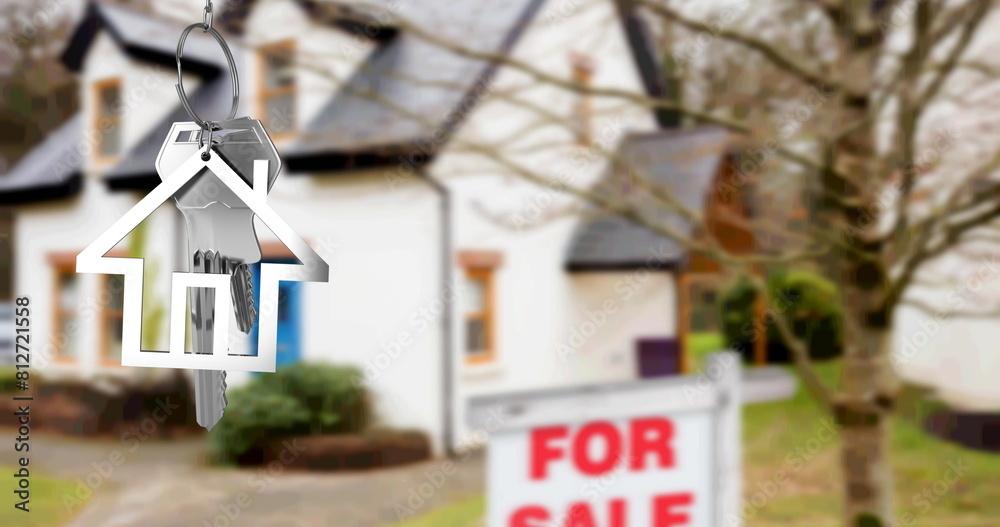 Image of silver house key fob and key, hanging in front of blurred ...