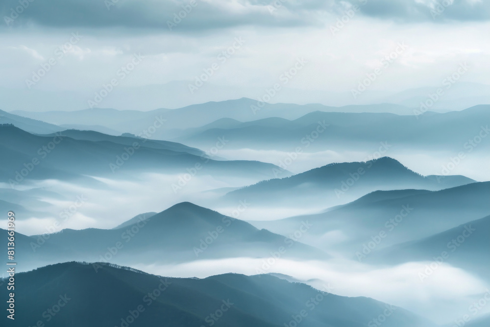 A tranquil view of the layers of mountain ridges disappearing into misty clouds, with their soft ...