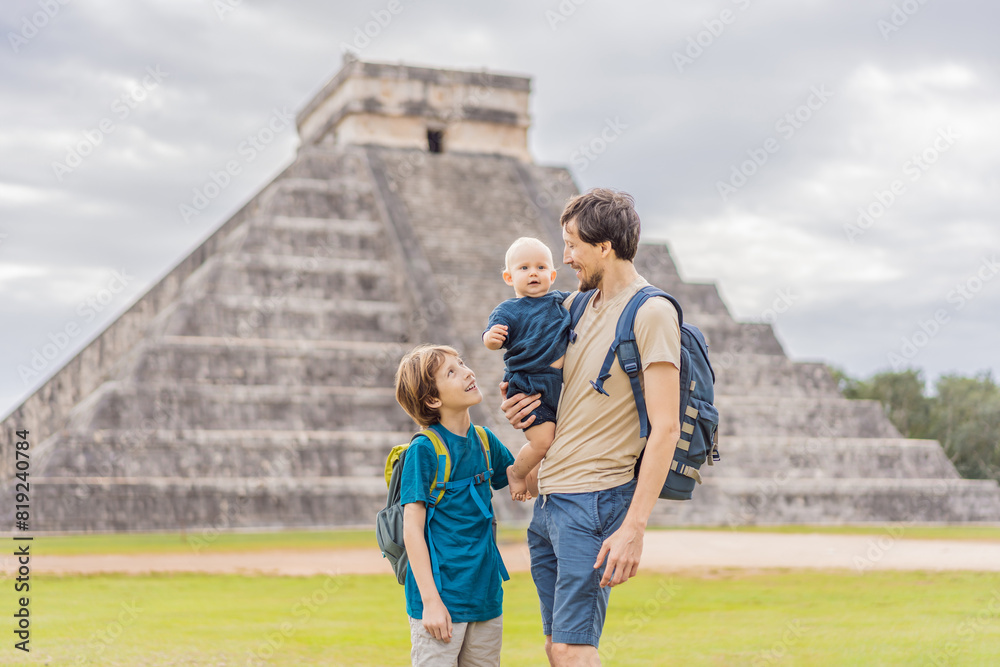 Father and two sons tourists observing the old pyramid and temple of ...