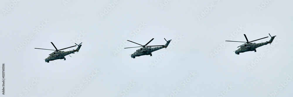 Three Russian military helicopters armed with missiles flies in blue ...