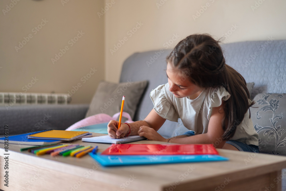 Little Elementary School Girl Doing Homework At Home, She Is Using ...