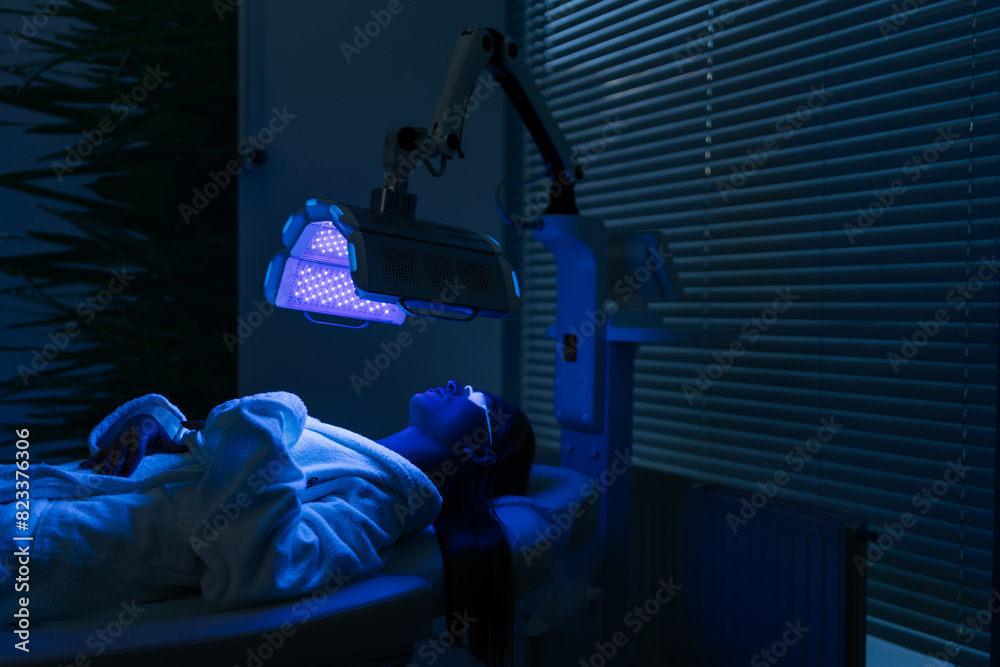 Remote view of female patient undergoes blue LED light therapy for skin ...