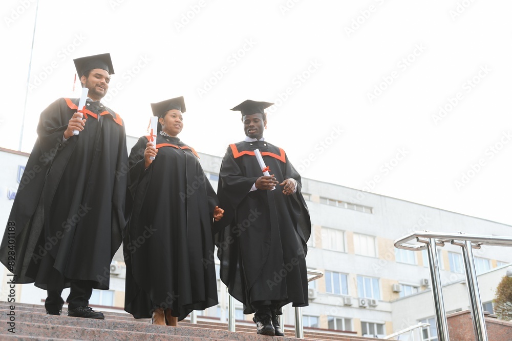 Group of happy smiling multicultural people in graduation gowns and ...