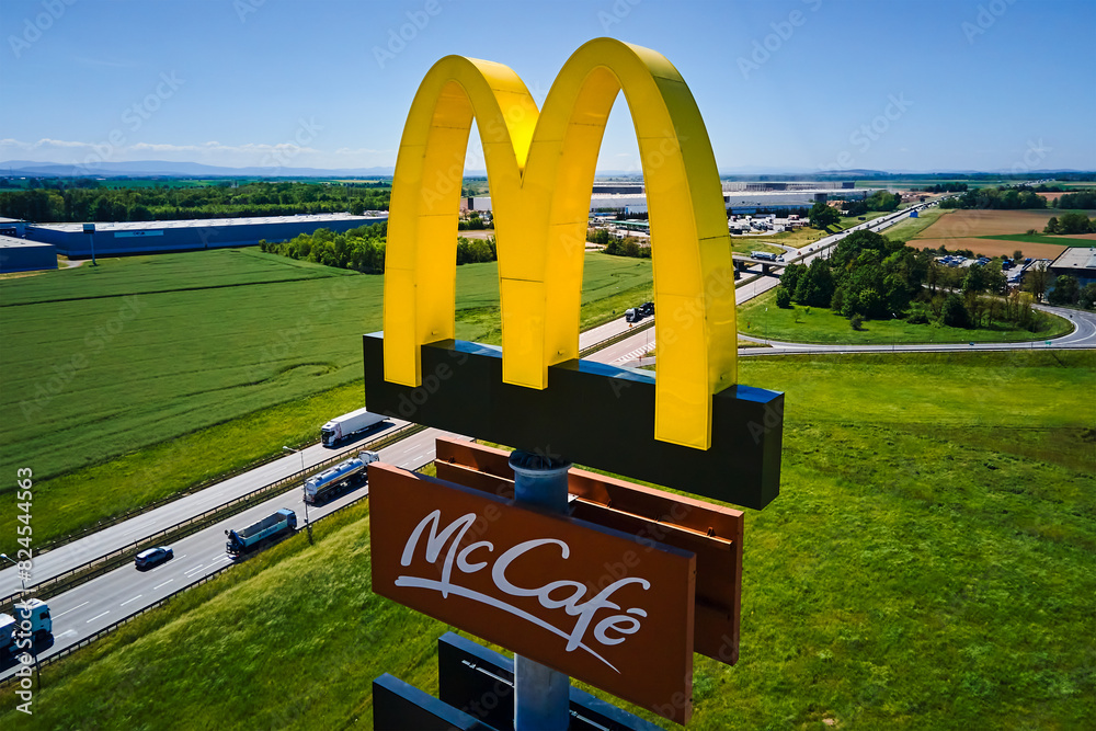Aerial view of Mcdonald's McCafe sign stands near busy highway with ...