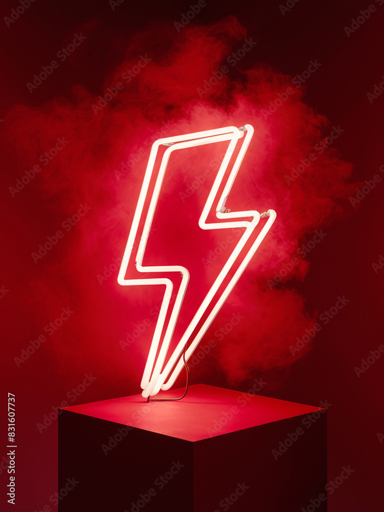 Neon lightning bolt sign in red, glowing on pedestal against smoky ...