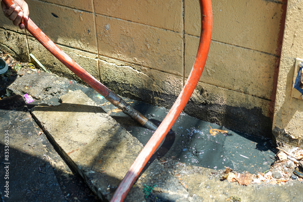 Worker hands using orange hose sucking mud and sludge removal from ...