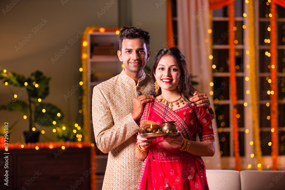 Young Indian asian couple in tradional wear at home celebrating Diwali ...