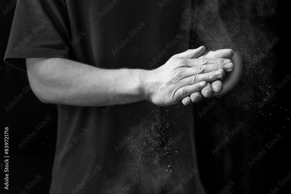 The hands of a strongman athlete clap chalk powder. Athlete preparing ...