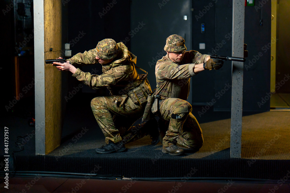 At a professional shooting range two military trainers perform tactical ...