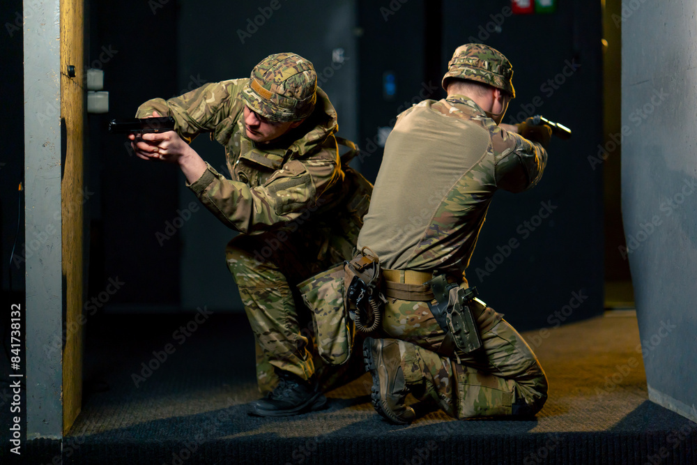 At a professional shooting range two military trainers perform tactical ...