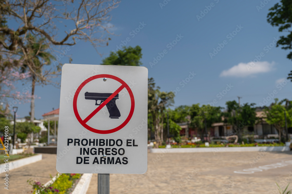 Sign with crossed hand gun and sign in Spanish entry with weapons ...