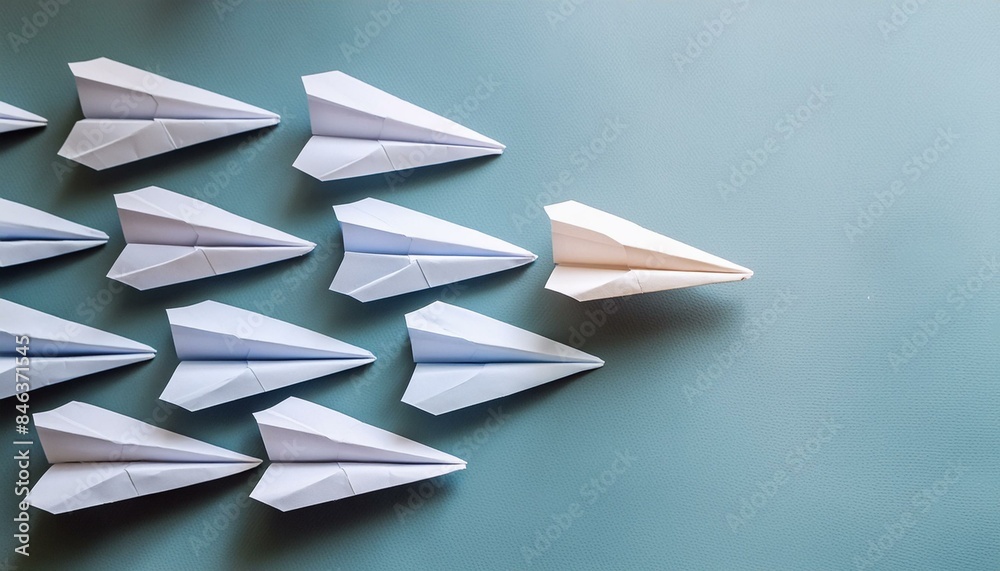 An array of paper airplanes demonstrating in the same direction over a ...
