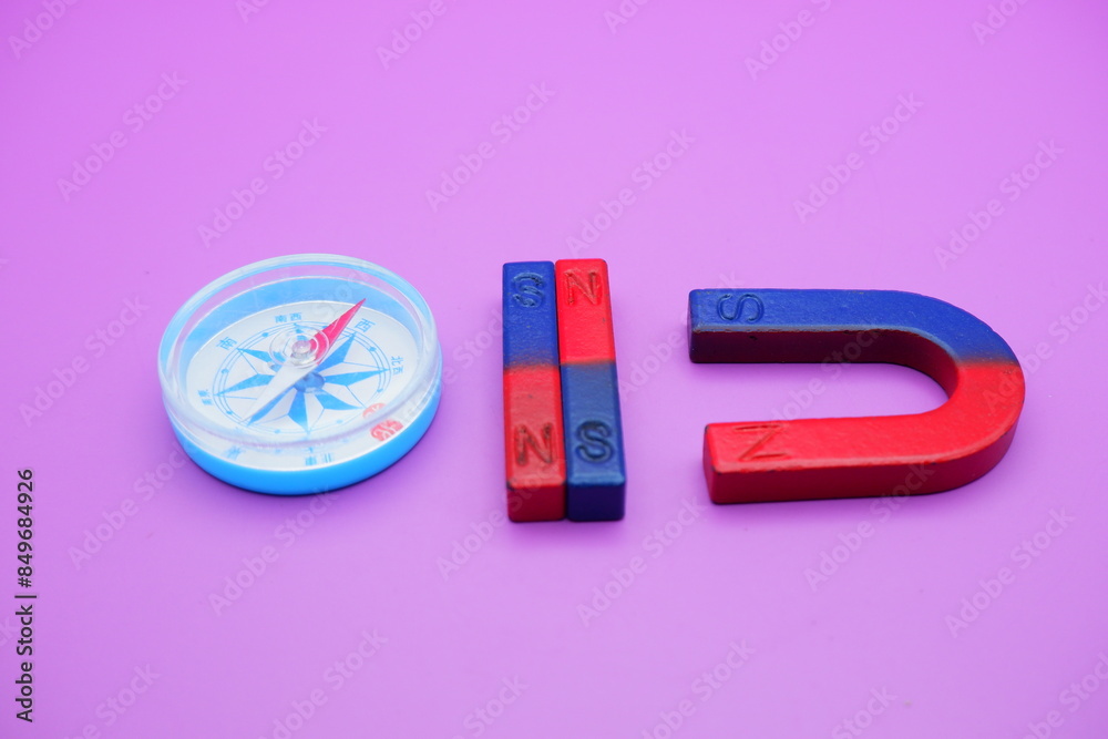 a compass, 2 bar magnets, and a horseshoe magnet isolated on a purple ...