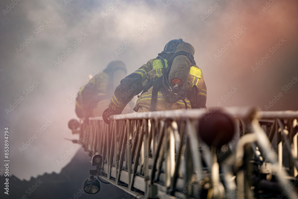 Fireman team extinguishes burn with hose water from ladder of aerial ...