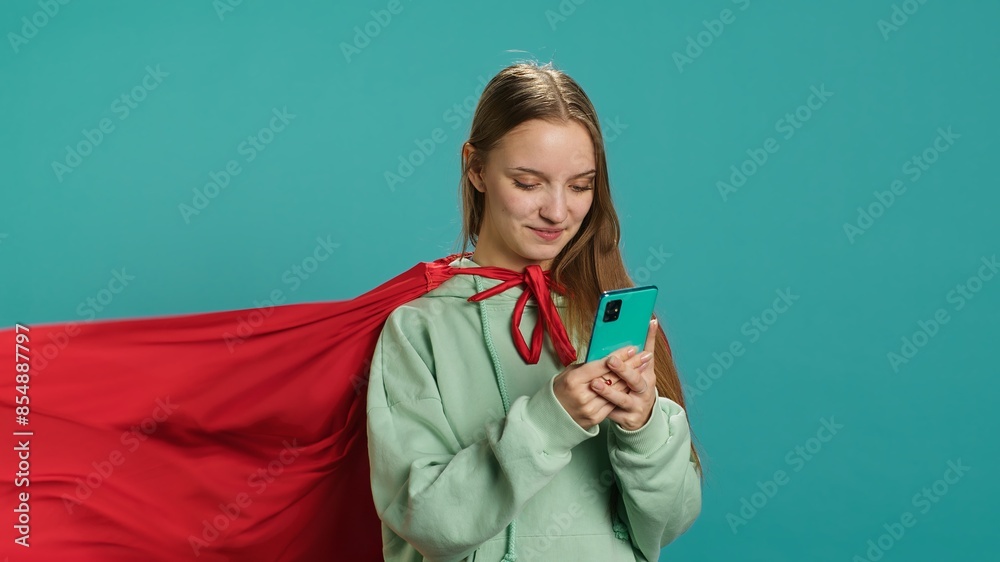 Young girl wearing superhero costume texting friends using smartphone ...