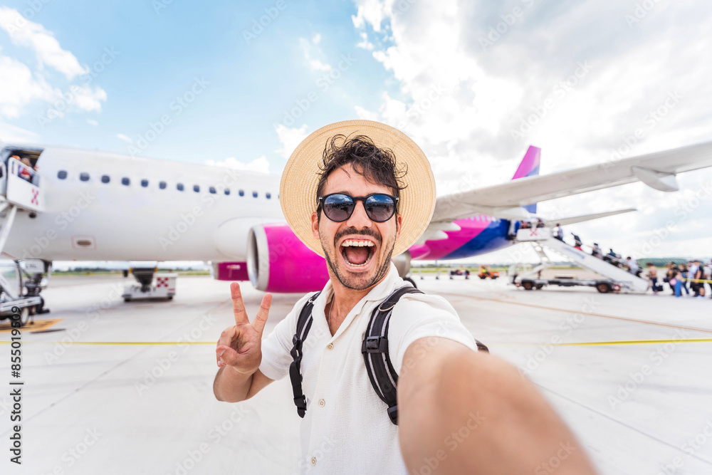 Happy tourist boarding on a plane at the airport - Handsome young man ...
