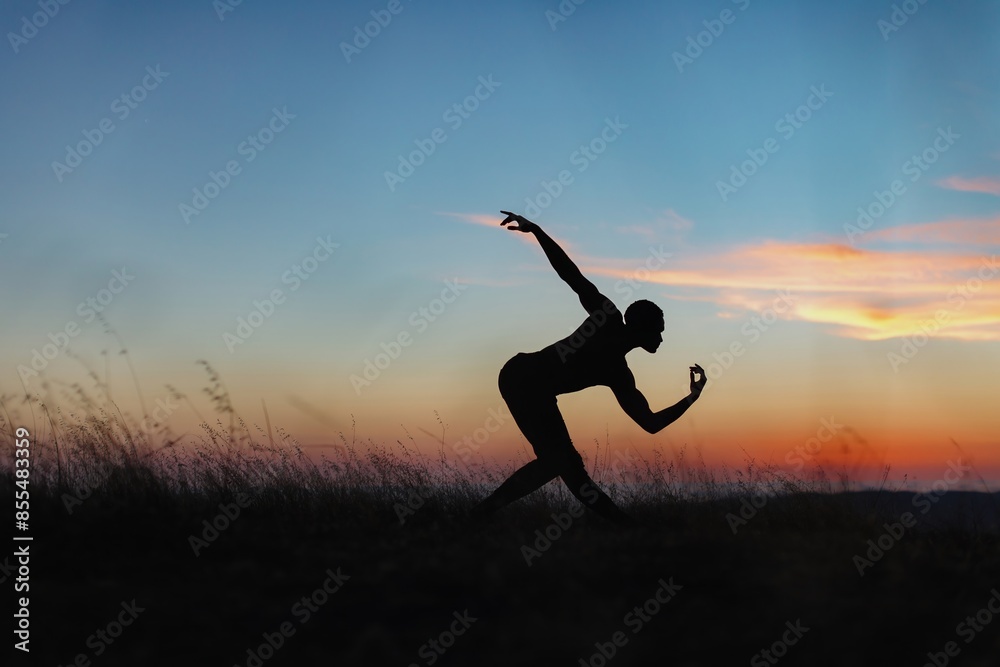 Silhouette of male ballet dancer doing a majestic dance move in nature ...