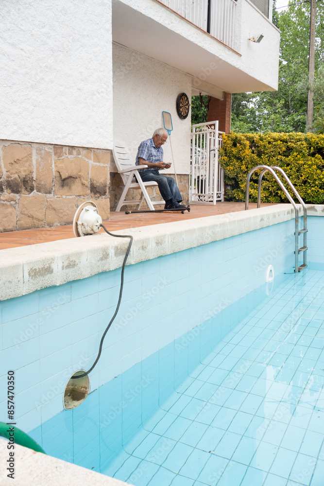 half-filled pool with hose refilling the water and spotlight outside ...