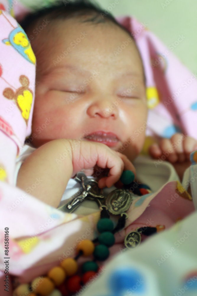 Newborn baby sleeping holding rosary in hand with Jesus Christ cross ...