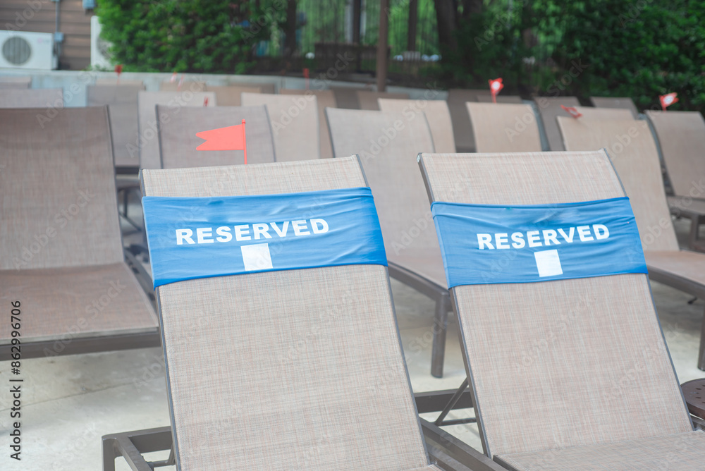 Reserved words wrap around pool lounge chairs, small plastic service ...