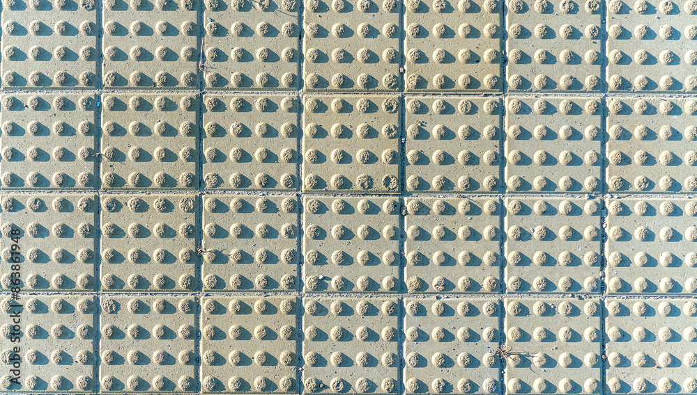 Tactile paving tiles with raised bumps on sidewalk. Surface texture ...