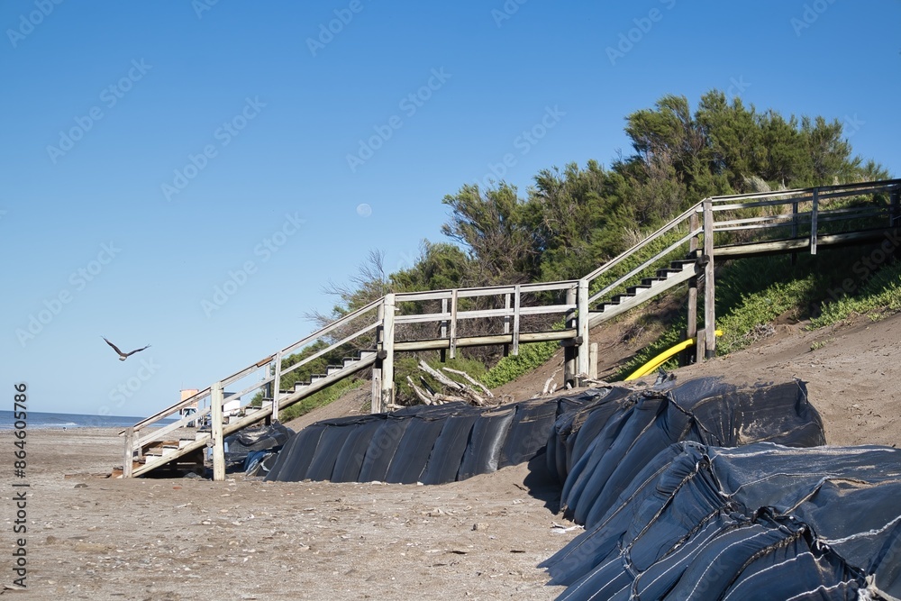 beach landscape, artificial barriers combat coastal erosion, wooden ...