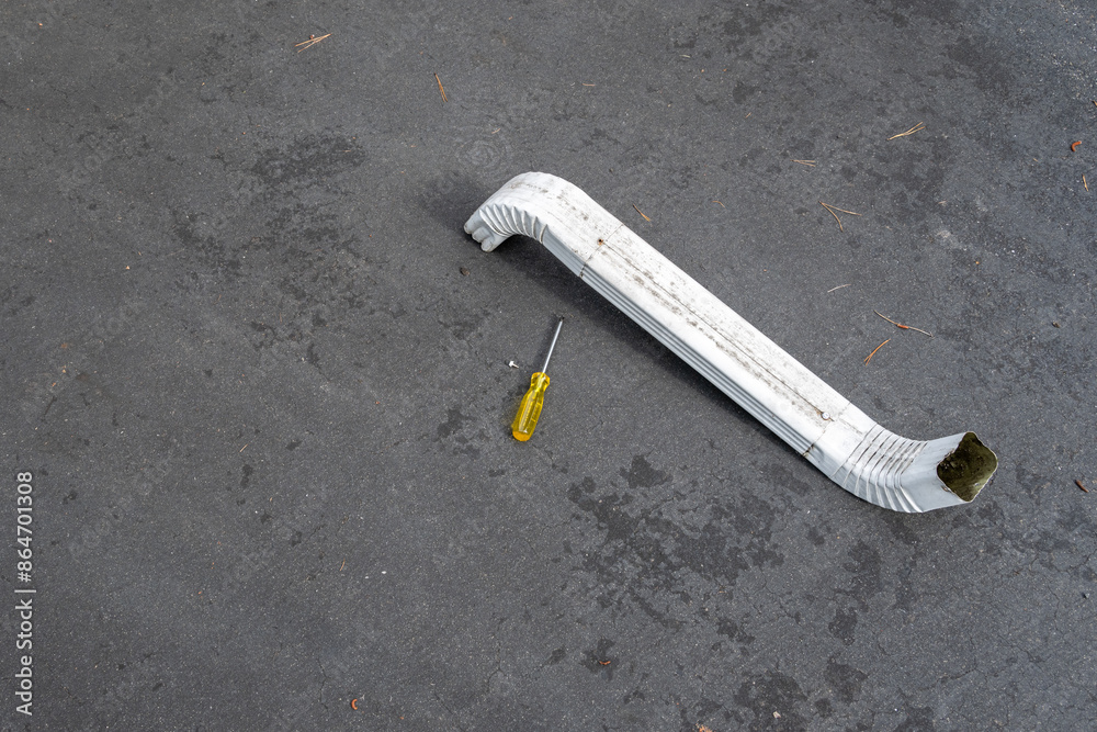 Section of white metal rain gutter downspout pipe with Phillips head ...