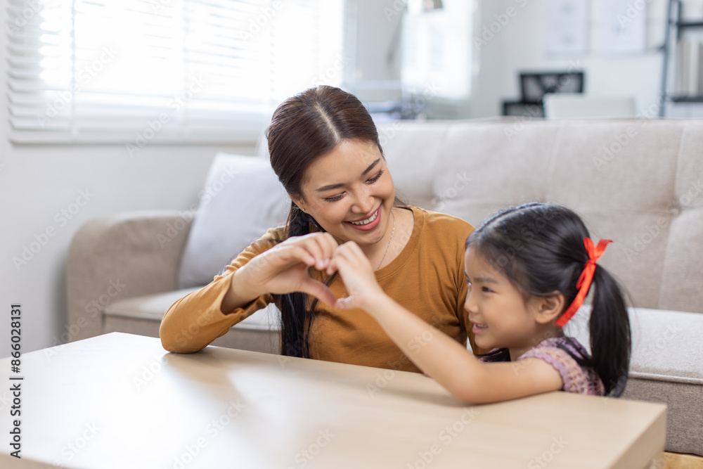 Setting good example. Young parent mother teach child little daughter ...
