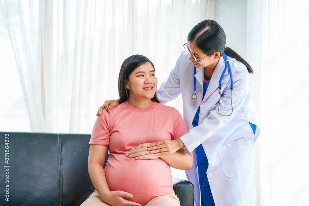 Asian female doctor nurse encouragement to a pregnant woman on a sofa ...