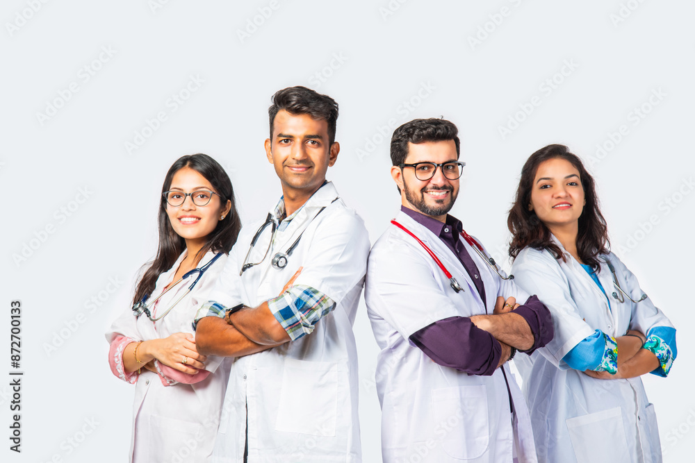 Group portrait of four indian asian young doctors in uniform standing ...