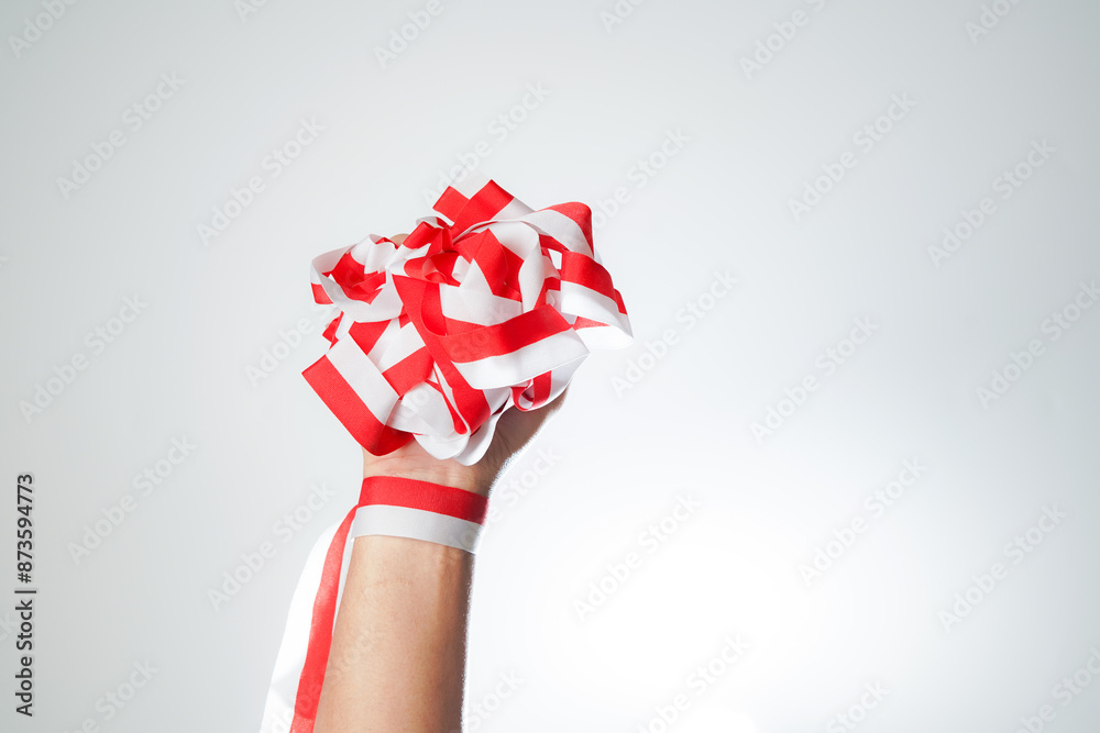 Human hands clenched into fists with red and white ribbons as a symbol ...