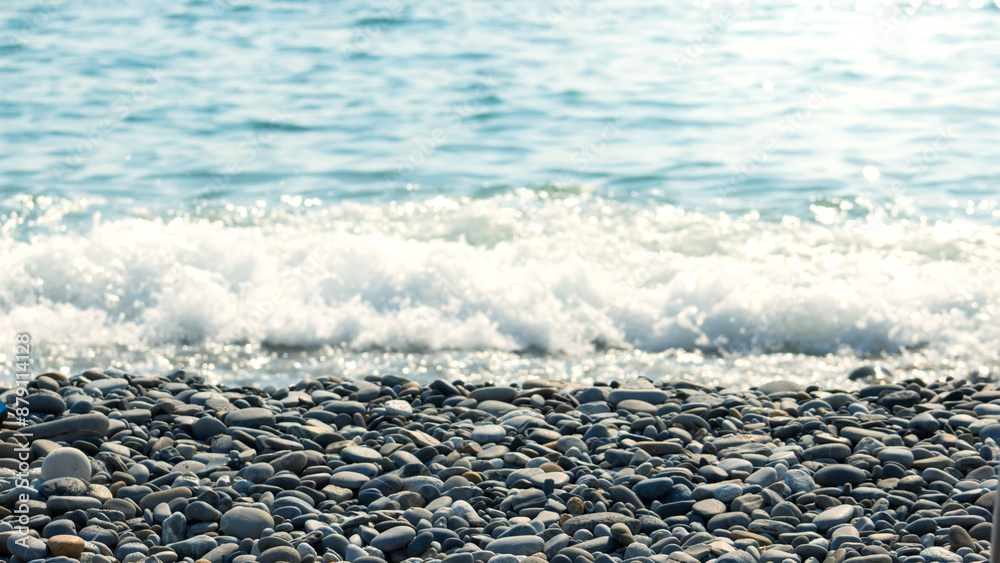 Pebble stones, sea water on beach shore close up, defocused natural ...