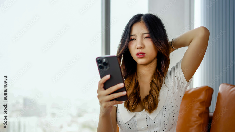 Stressed young asian woman suffering from neck pain while texting on ...