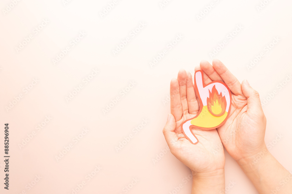 Human stomach burn with acid reflux and fire made from paper on hands ...