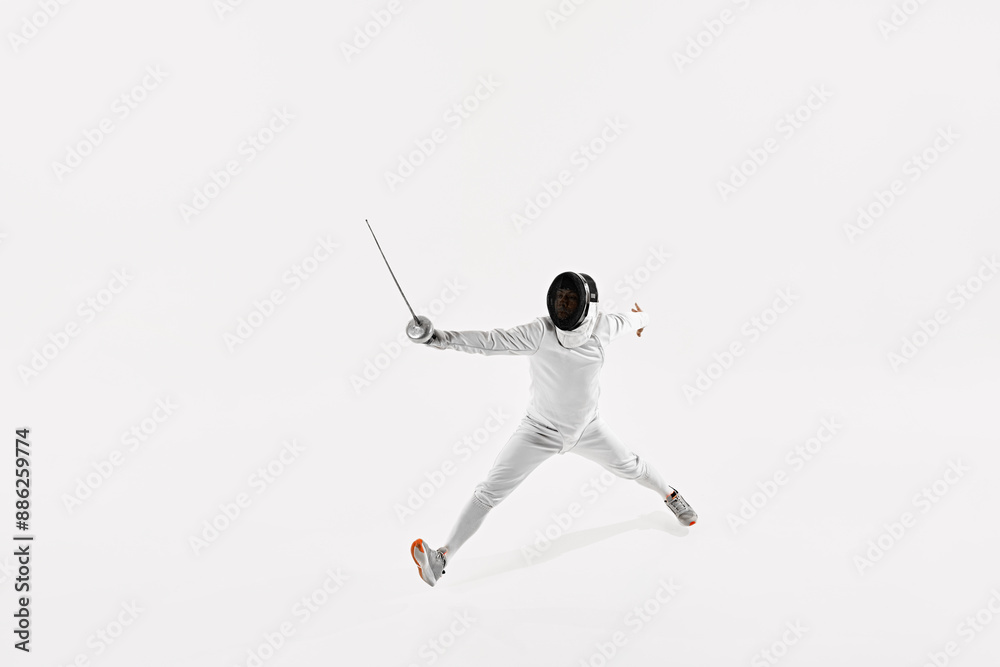 Fencer wearing white suit and mask in mid-air, with their rapier ...