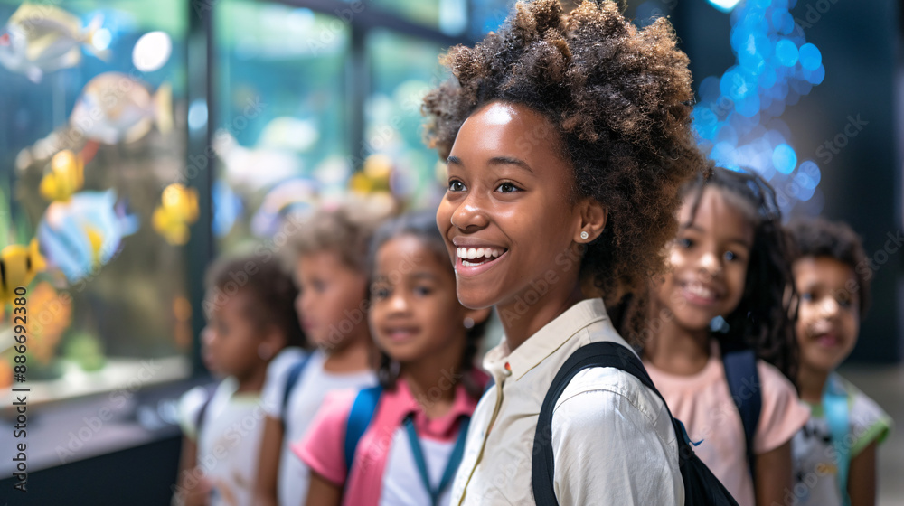 Smiling teacher leading a group of elementary school children on a ...