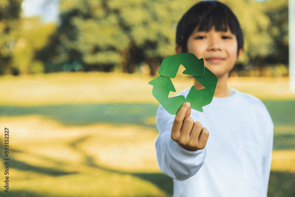 Cheerful young asian boy holding recycle symbol on daylight natural ...