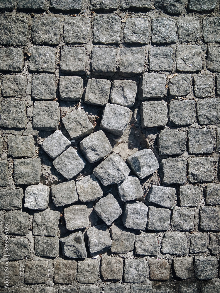 Broken paving slabs made of natural granite are laid out with a pattern ...