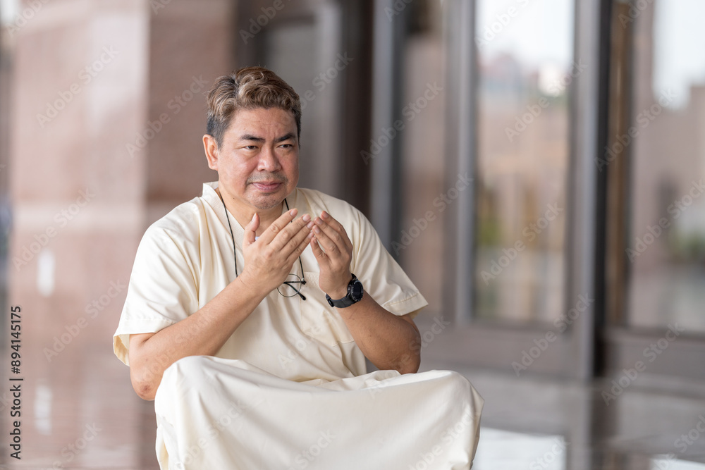 Fifty-something Muslim Malay person in religious attire, wearing a ...