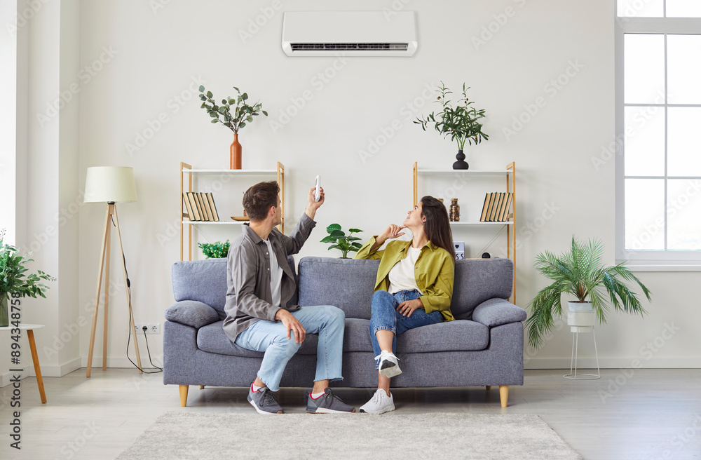 Young married couple relaxing sitting on couch and enjoying their new ...