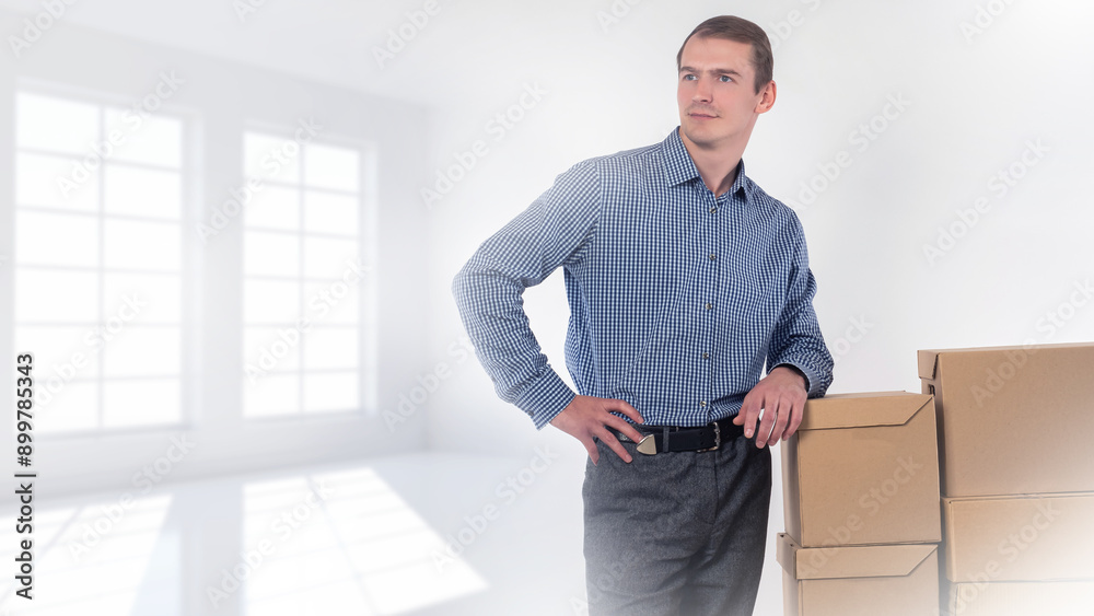 Man is engaged in moving. Guy with boxes in empty room. Relocation to ...
