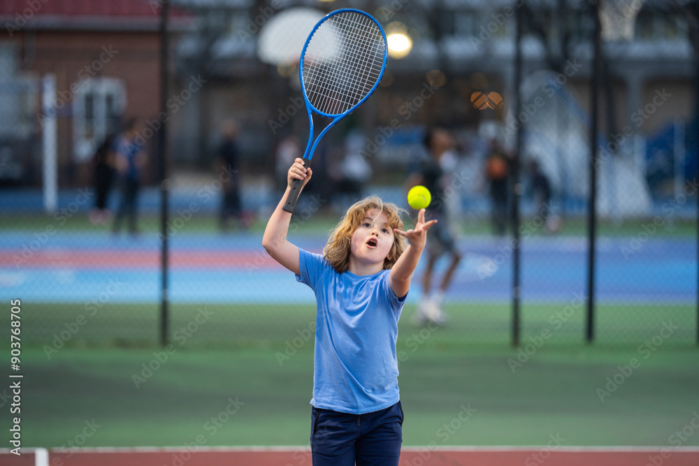 Preteen child swinging racket while training on tennis court at sport ...
