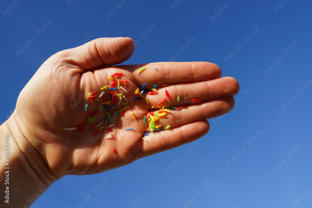Microplastic pollution. Microplastics on a hand against a blue sky ...