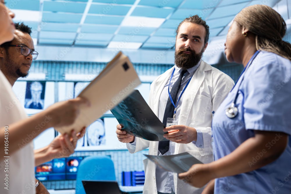 Medical experts analyze radiography scans in a meeting with the staff ...